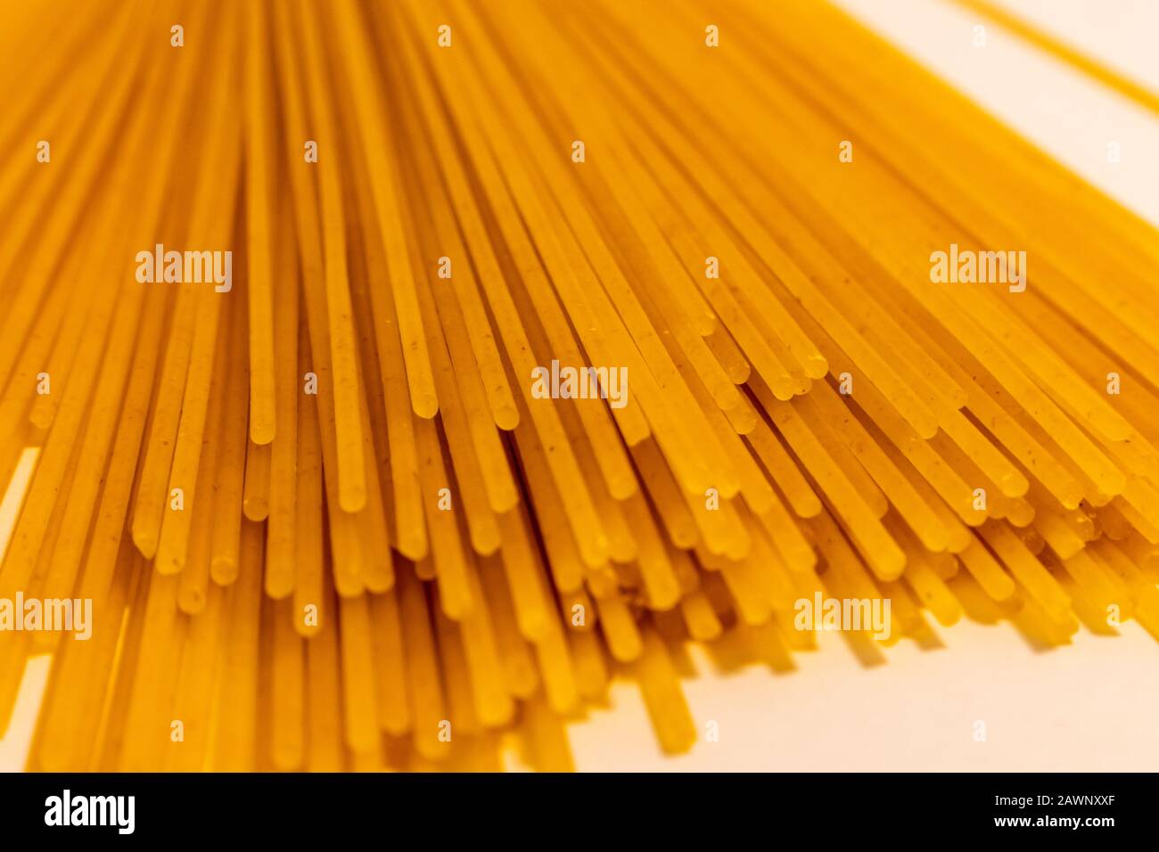 A close-up view of dry spaghettini pasta shows the ends of the dried ...