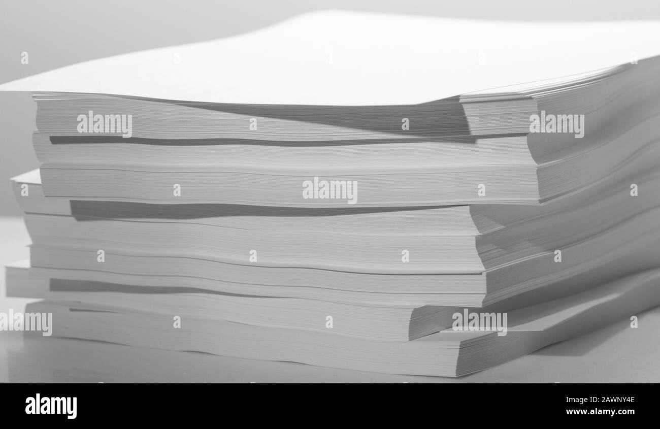 Several stacks of white paper on a white background Stock Photo - Alamy