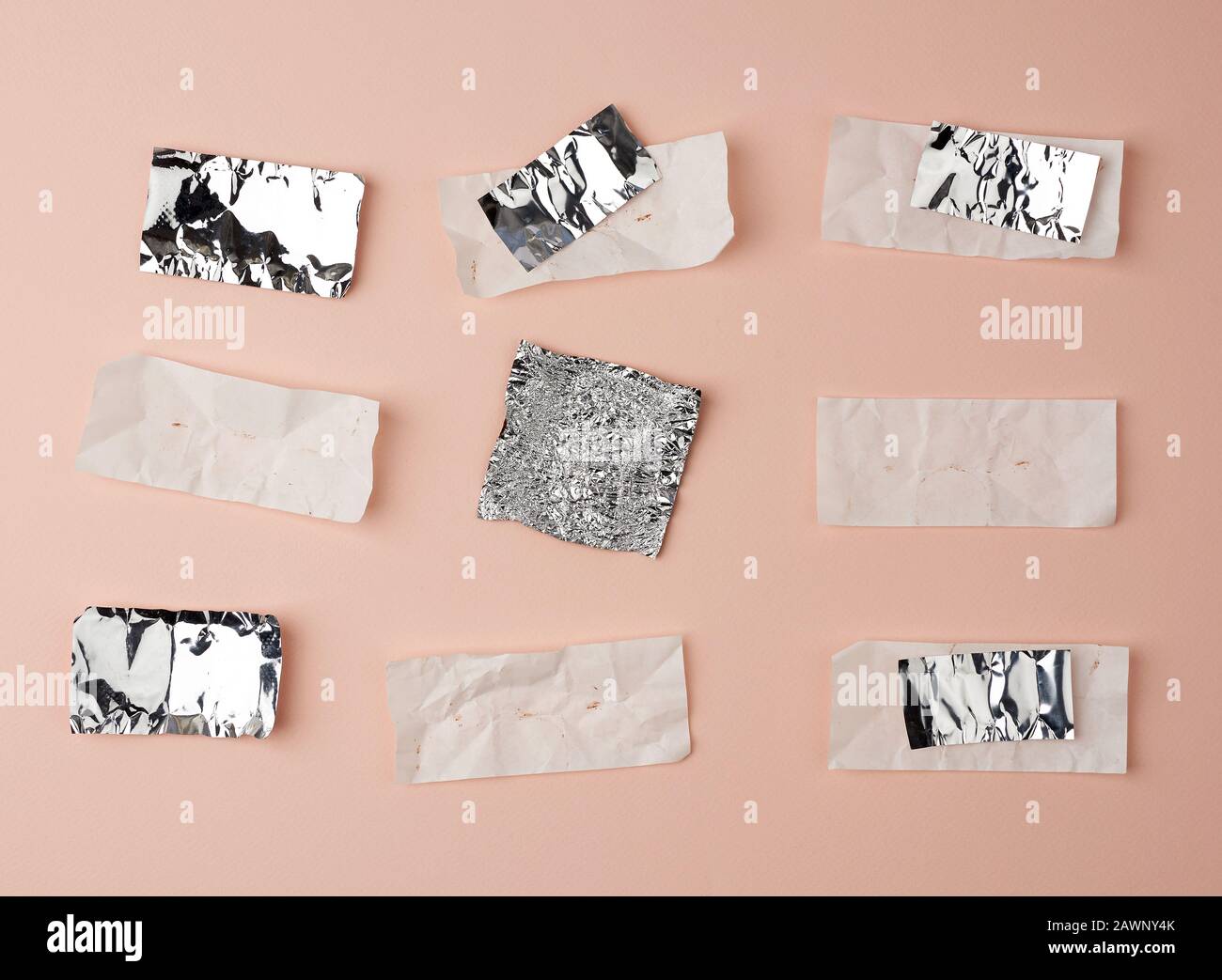 various crumpled foil used candy wrappers on a beige background, top ...