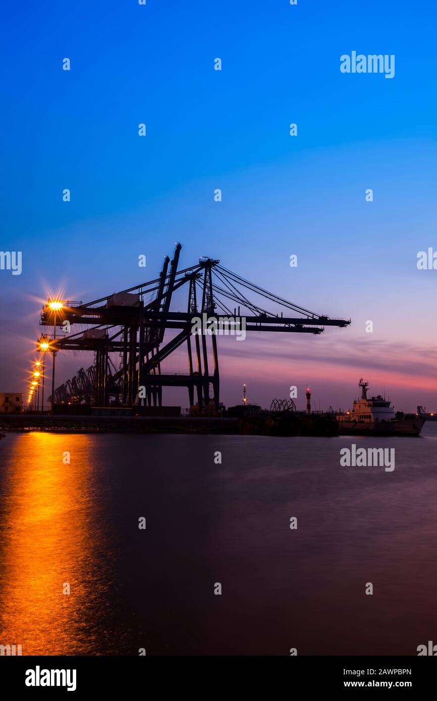 Freight dock of container crane at night Stock Photo - Alamy