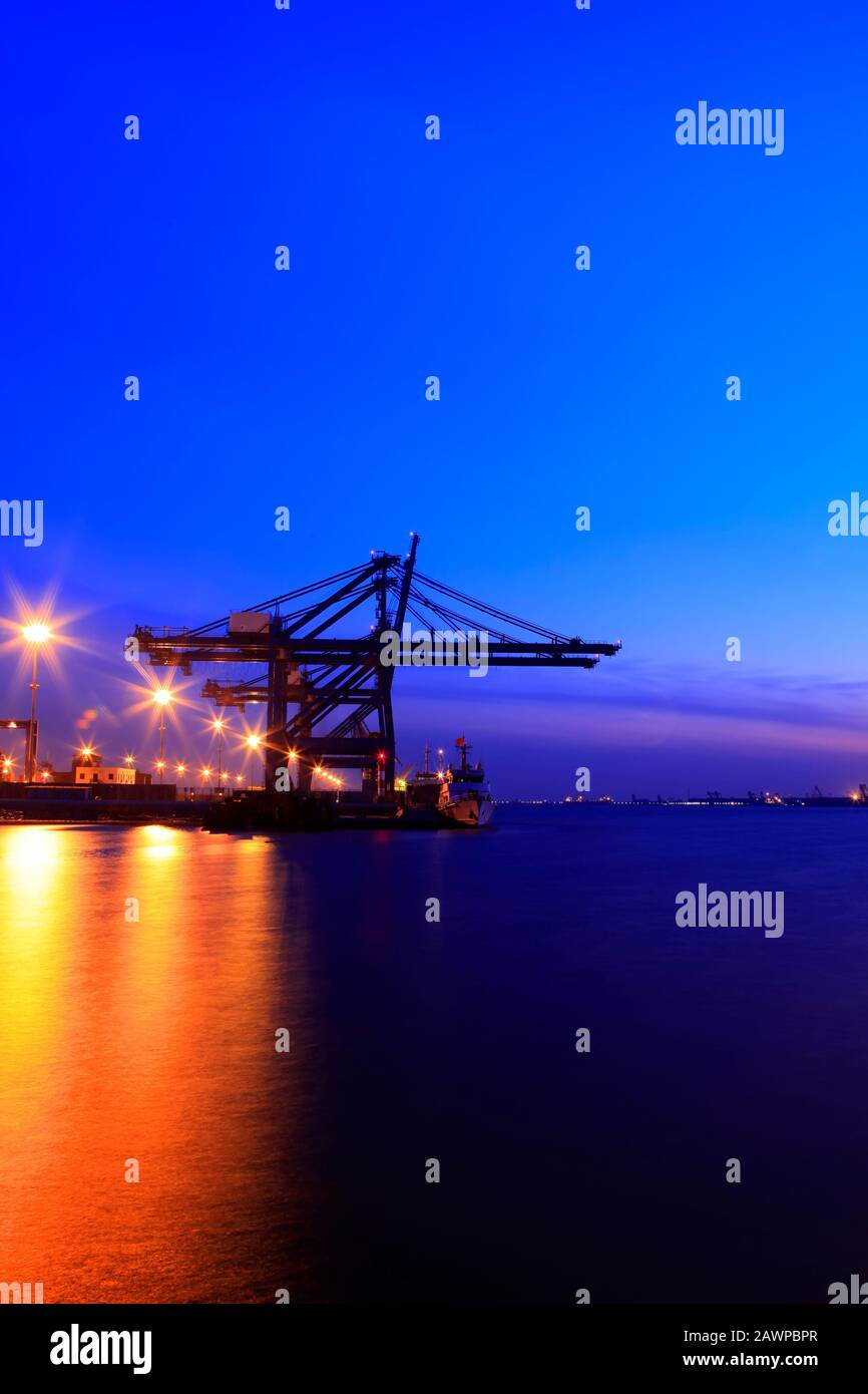 Freight dock of container crane at night Stock Photo - Alamy