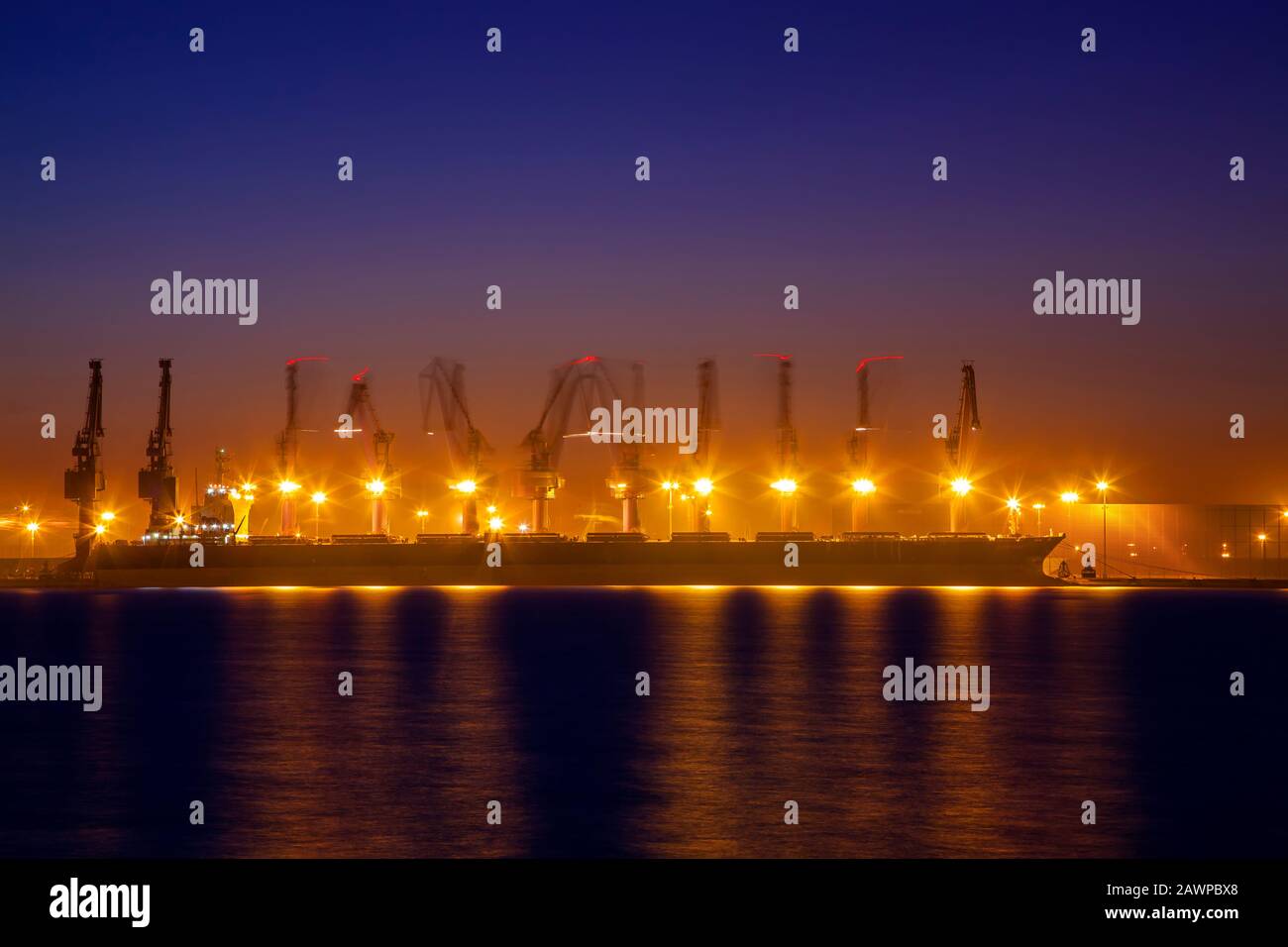 Freight dock of container crane at night Stock Photo - Alamy
