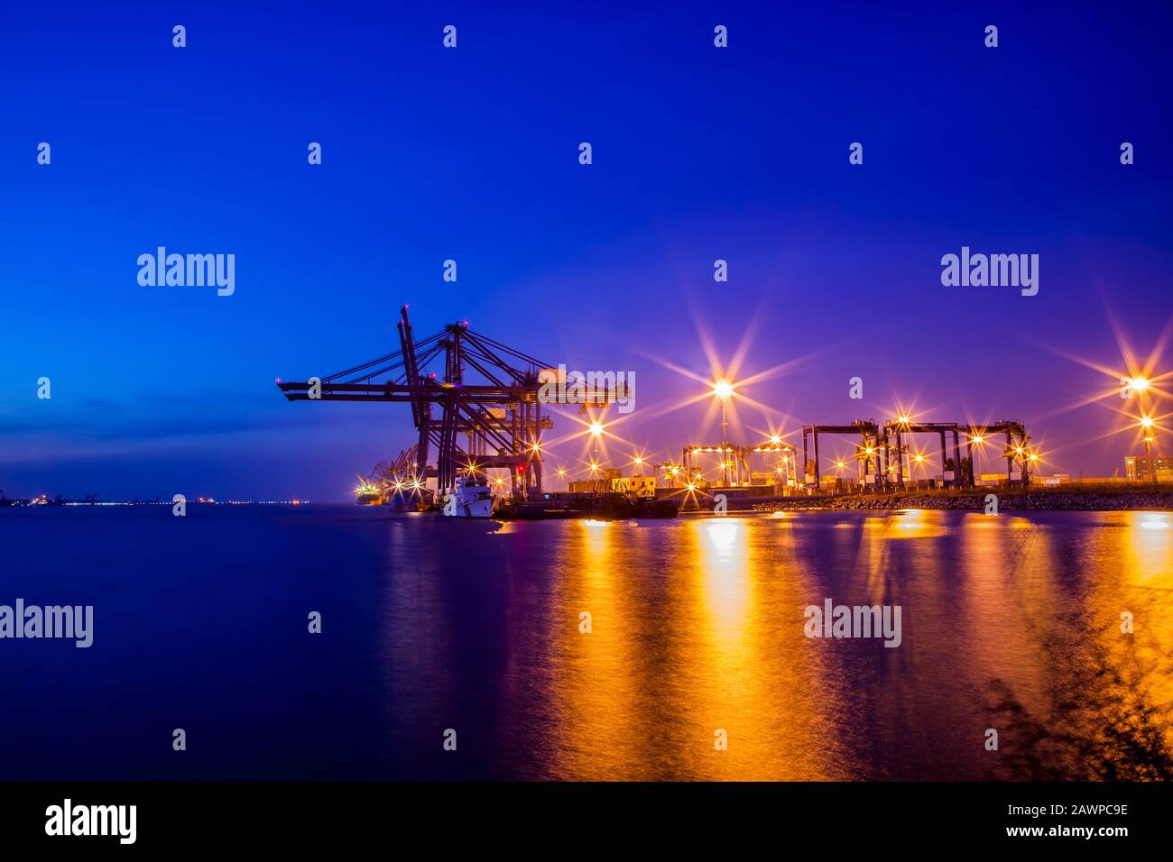 Freight dock of container crane at night Stock Photo - Alamy