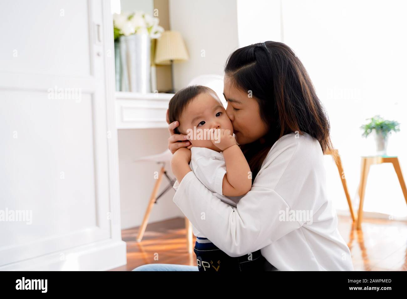 Asian Young Adult Mother Kissing Joyful Son In Living Room Love Of