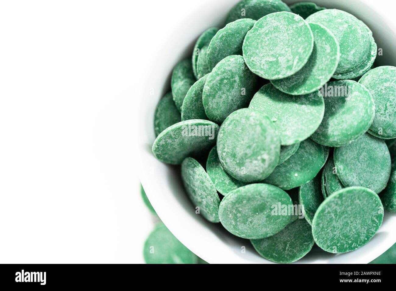 Green round chocolate chips for melting chocolate shapes on a white ...
