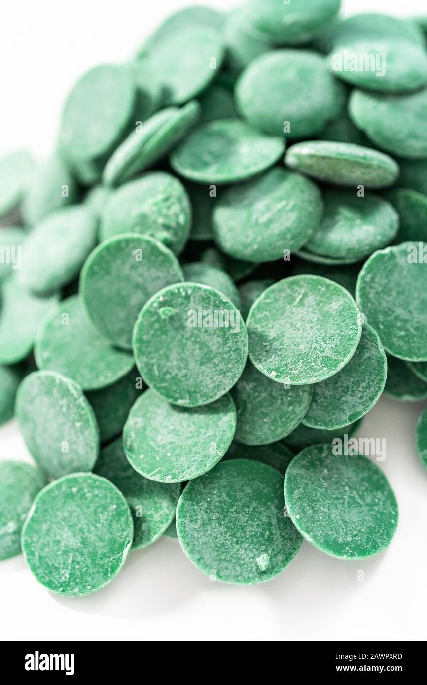 Green round chocolate chips for melting chocolate shapes on a white ...