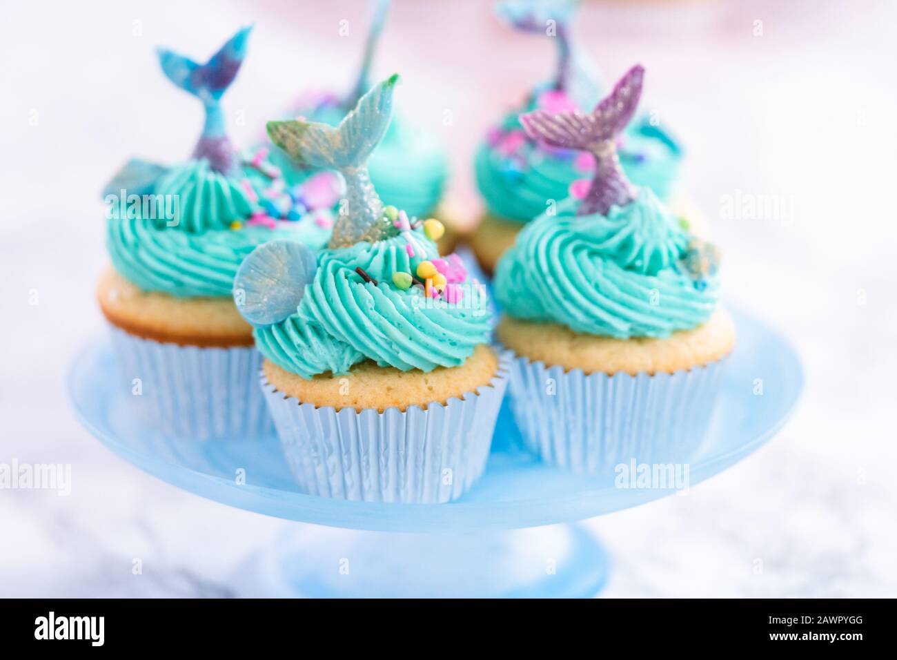 Gourmet mermaid cupcakes topped with blue buttercream frosting and ...