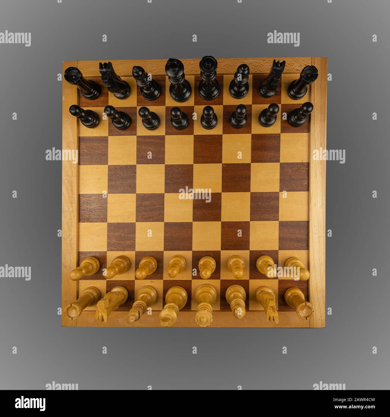 Overhead shot of a black and brown classic chessboard on a dark surface ...