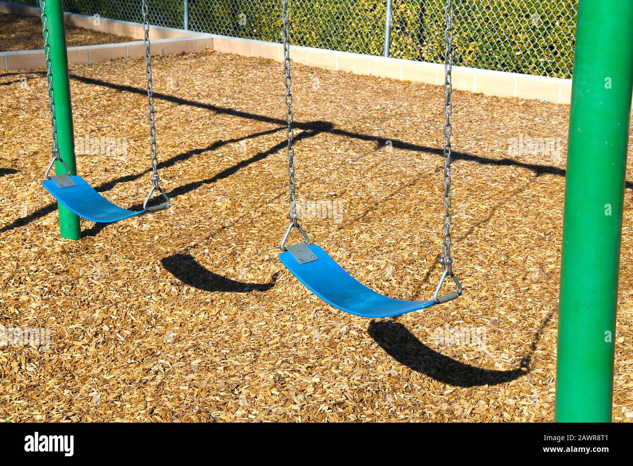 2 blue swings in a park playground Stock Photo - Alamy