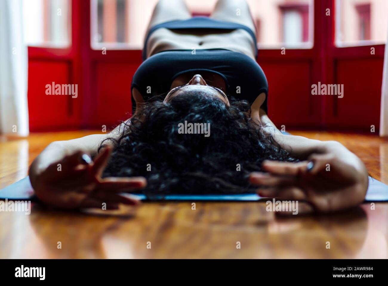 Woman doing yoga in a studio showing the bridge position with hands ...