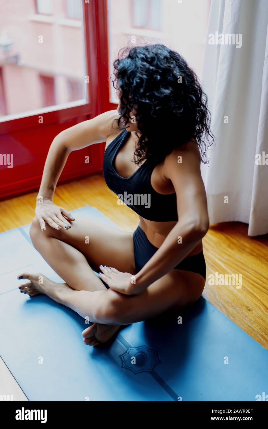 High angle side view shot of a woman doing stretching in an Indian sit position Stock Photo - Alamy