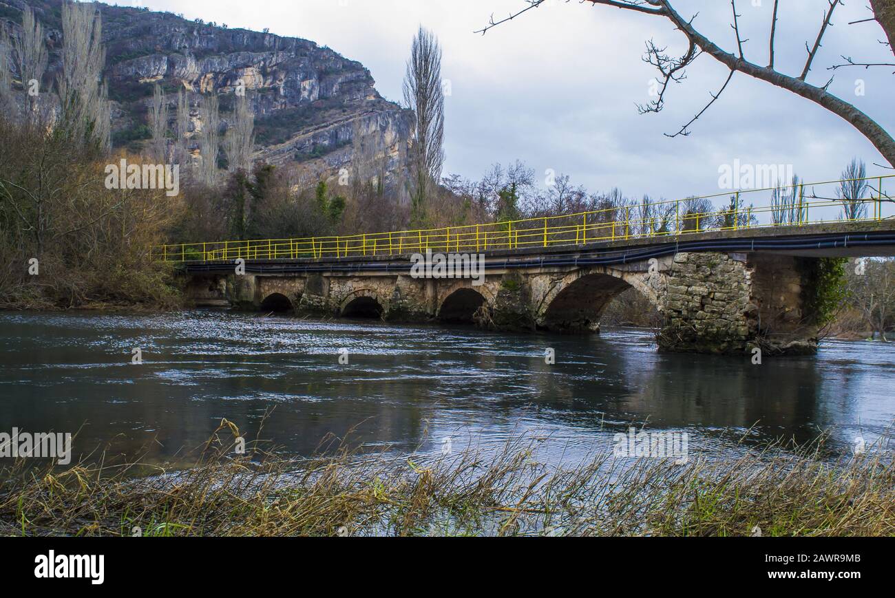 Arch bridge over the river surrounded by rocks in Krka National Park in ...