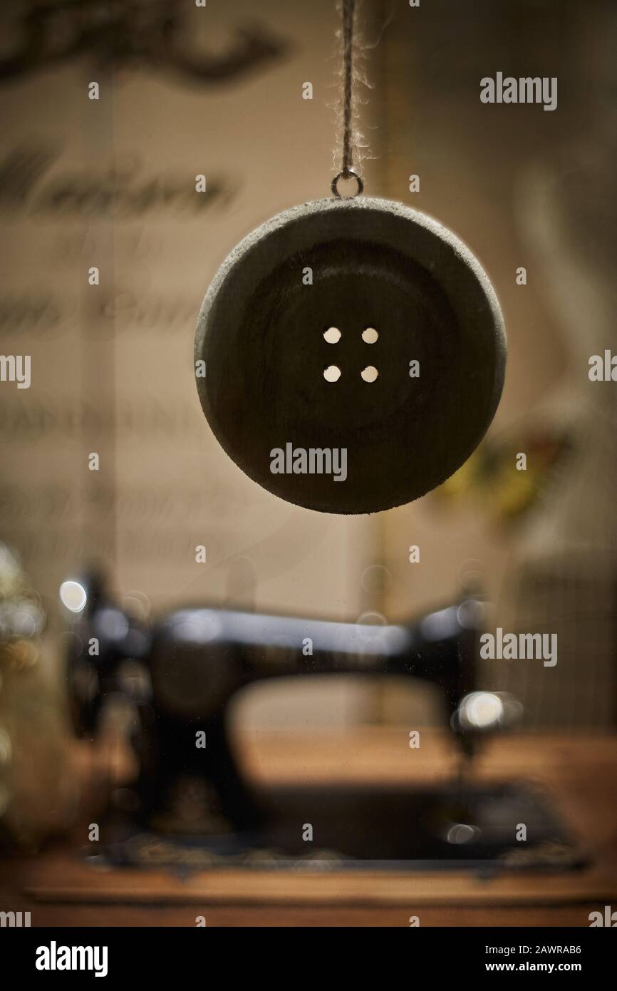 Vertical shot of a hanging button inside a tailor's studio with a ...