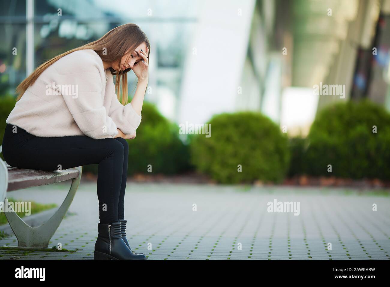 Woman stressed from work while sitting outdoors Stock Photo - Alamy