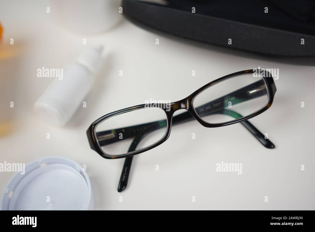 Glasses on white counter with various eye care products. Flat lay of ...