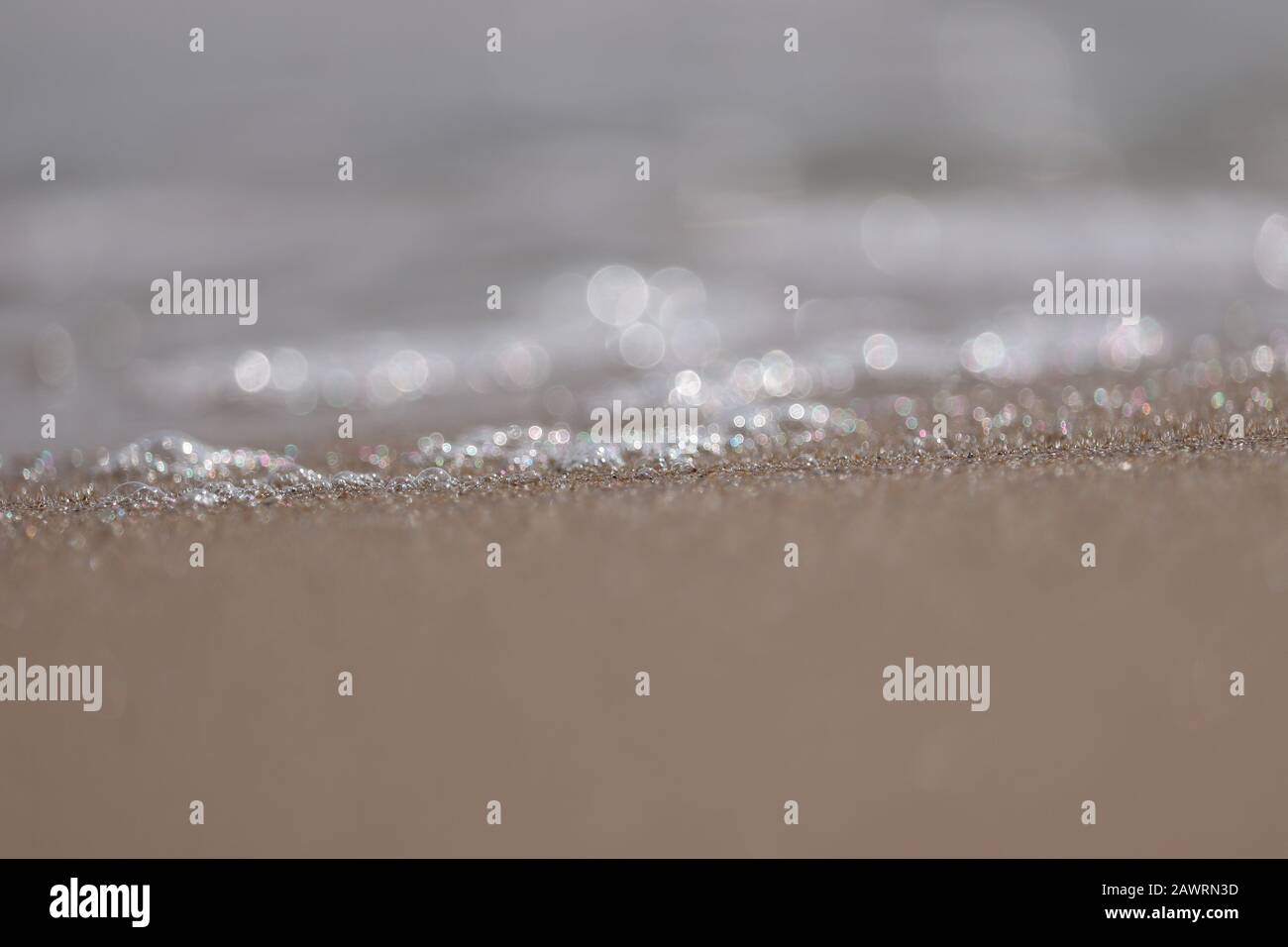 close up sharp shot of sea water wave on beach with selective focus ...