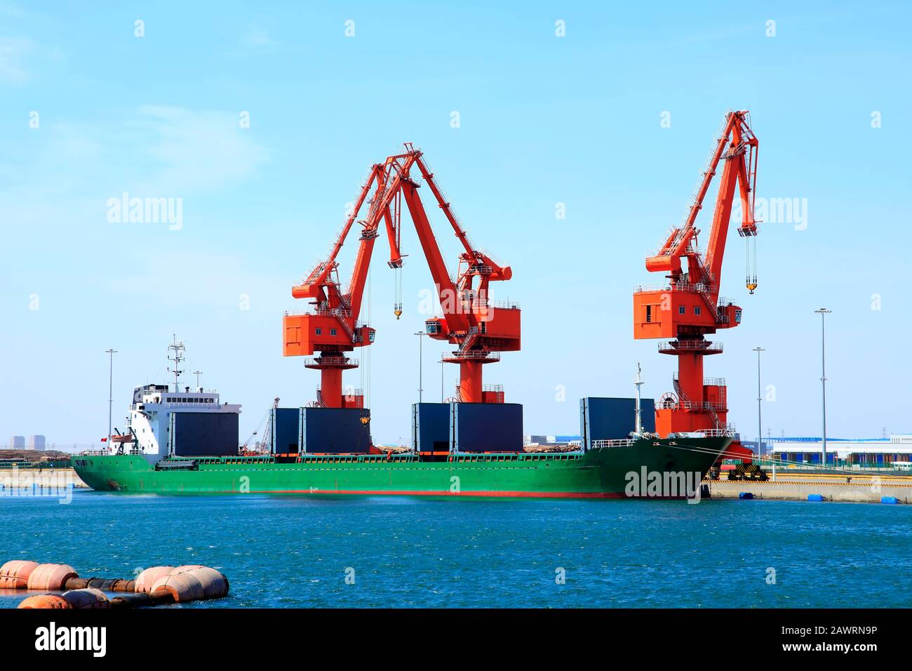 In freight terminal, gantry crane and cargo ships are in loading and ...