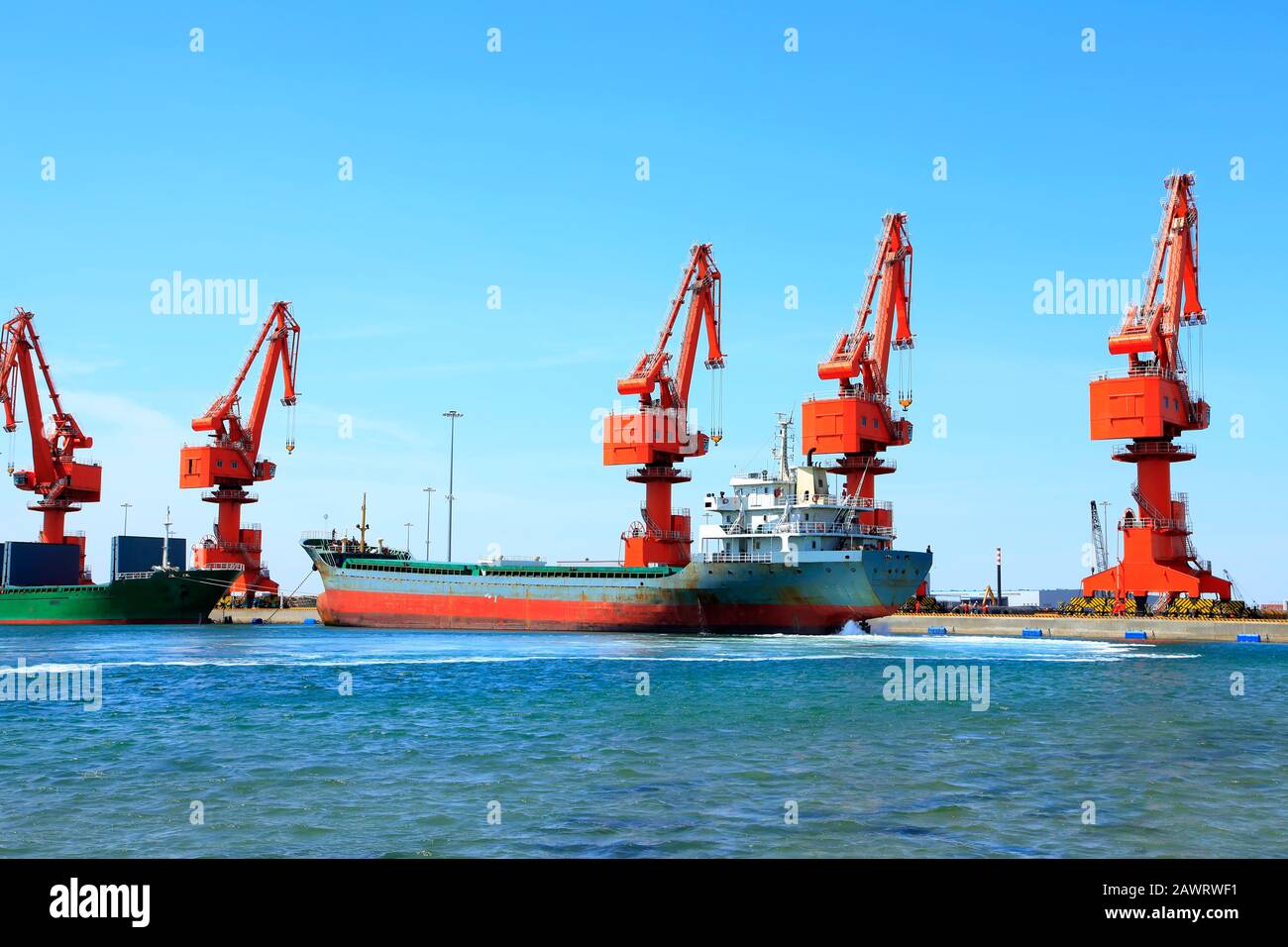 In freight terminal, gantry crane and cargo ships are in loading and ...