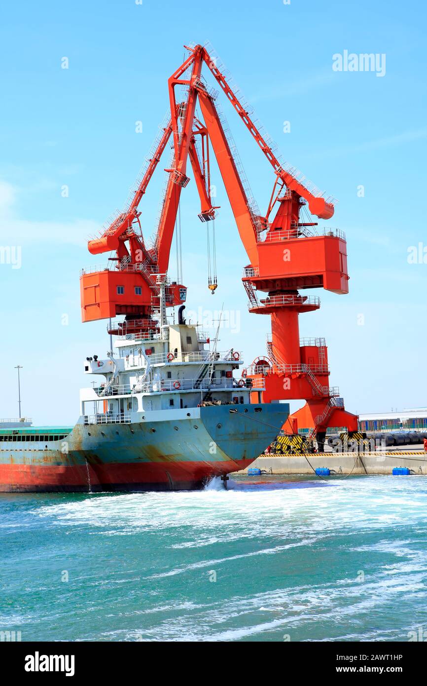 In freight terminal, gantry crane and cargo ships are in loading and ...