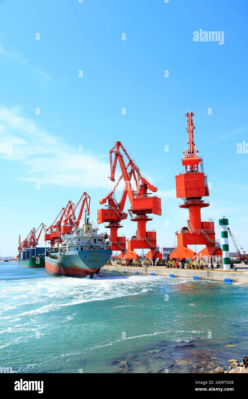In freight terminal, gantry crane and cargo ships are in loading and ...