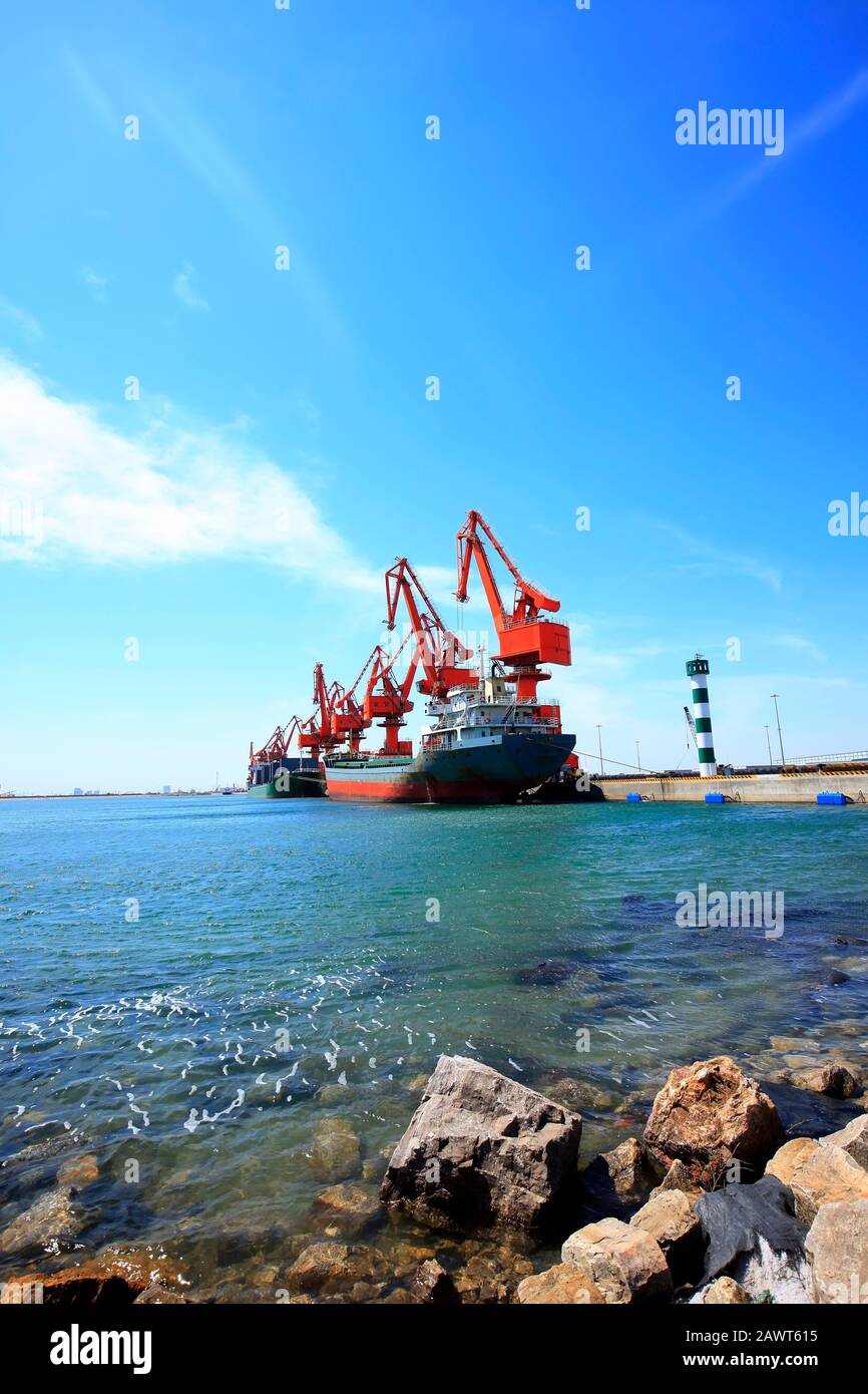 In freight terminal, gantry crane and cargo ships are in loading and ...
