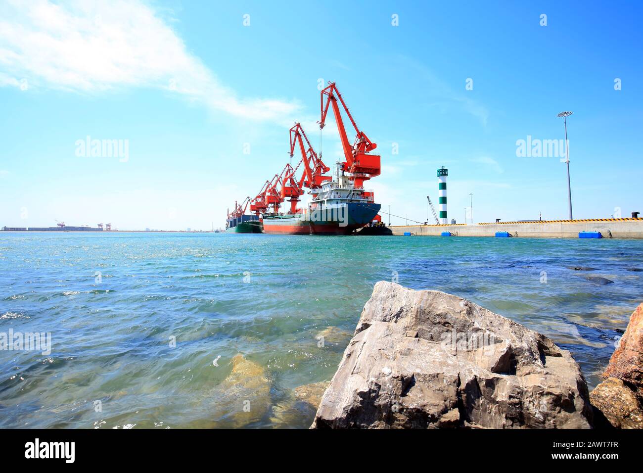In freight terminal, gantry crane and cargo ships are in loading and ...