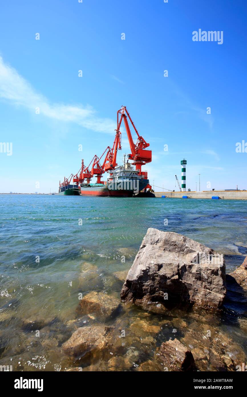 In freight terminal, gantry crane and cargo ships are in loading and ...