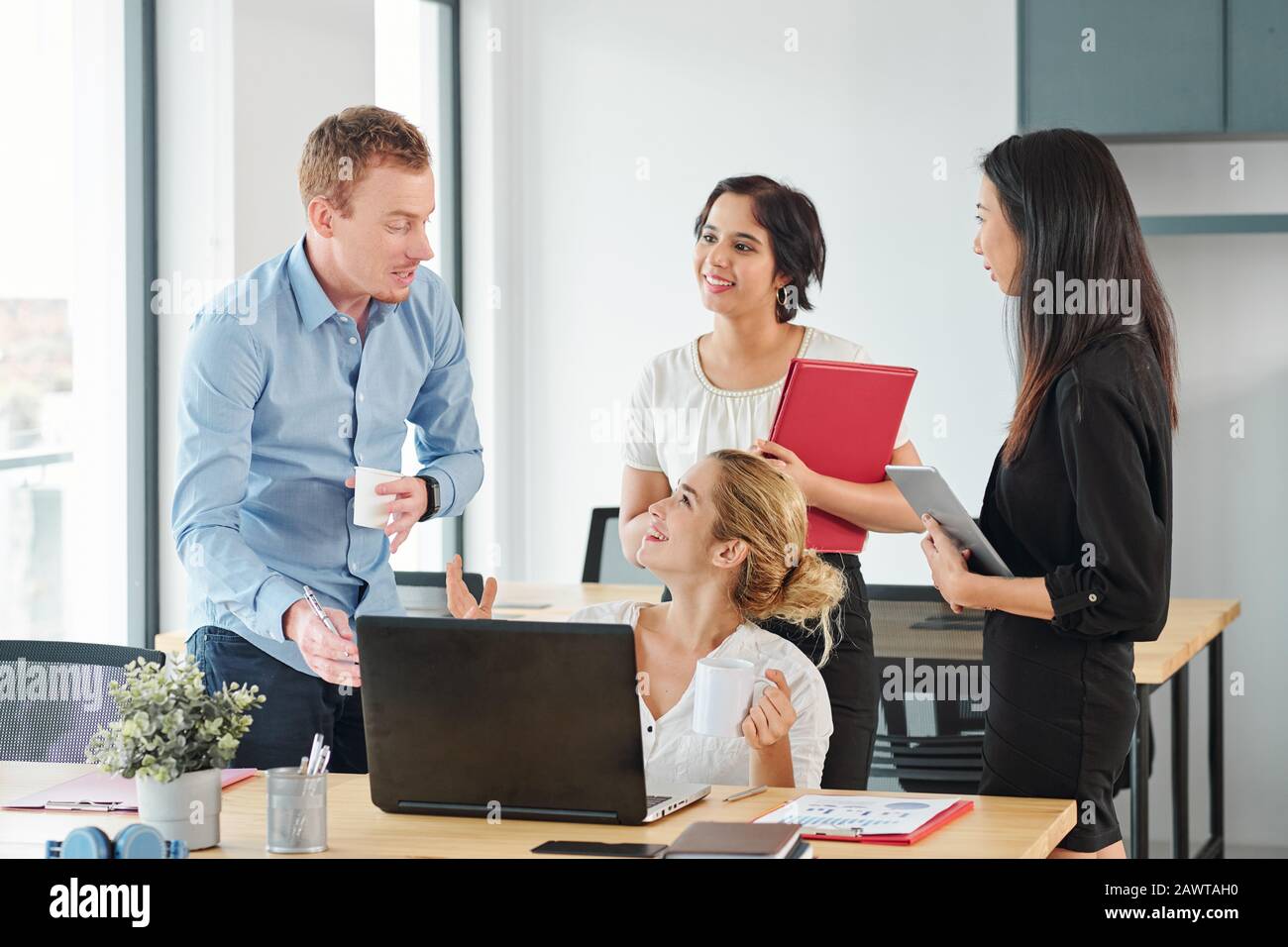 Team of young cheerful business executives discussing new creative ...