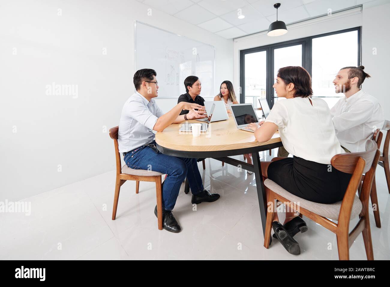 Start-up project managers gathered at table to discuss marketing ...