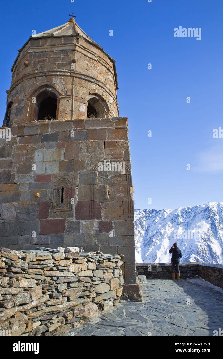 Gergeti Trinity Church, Georgia in winter with figure Stock Photo - Alamy