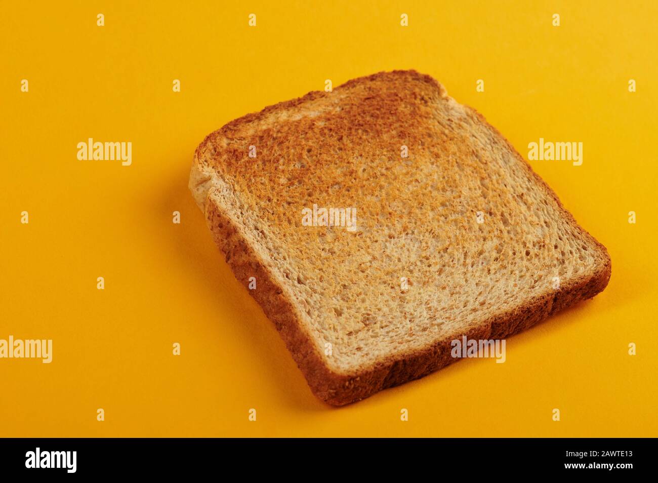 Side view of wheat bread toasted piece isolated on yellow background ...