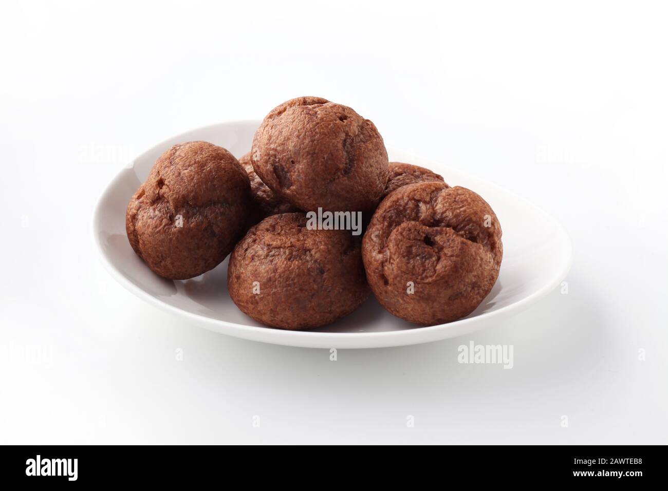 chocolate cream puffs on plate closeup isolated on white background ...