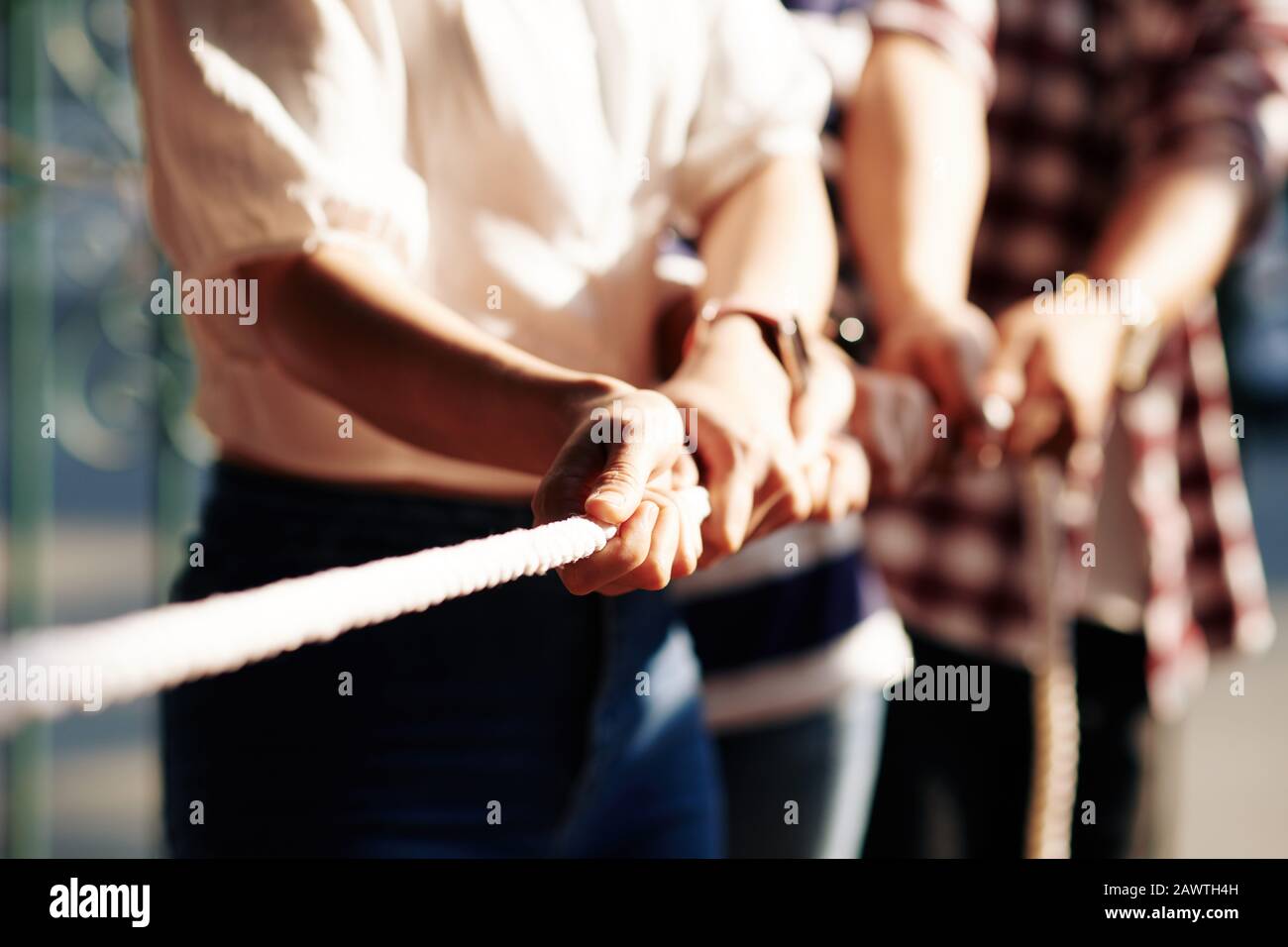 Cropped image of coworkers playing tug of war for developing ...