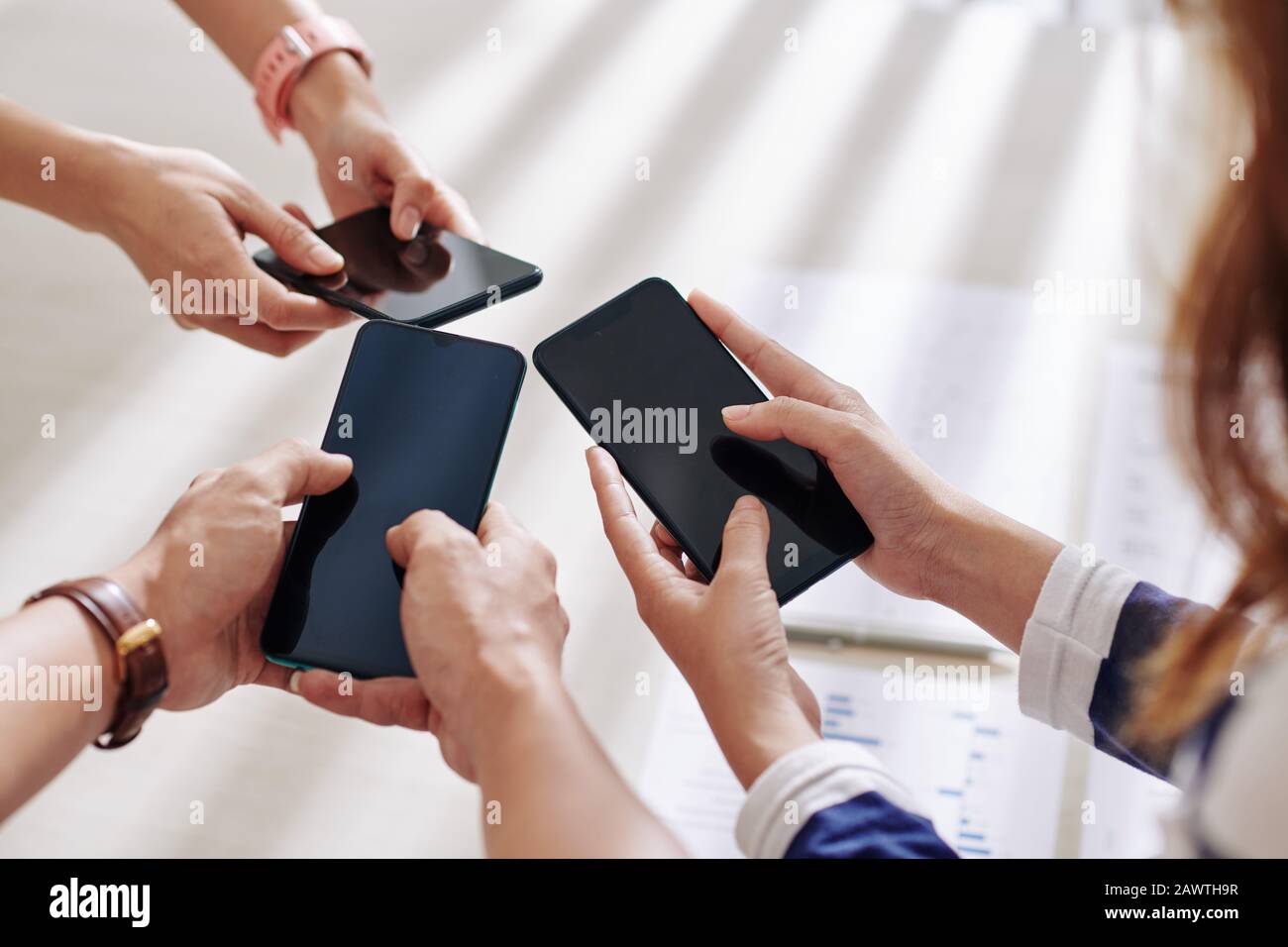 Group of business people using applications on smartphones for ...