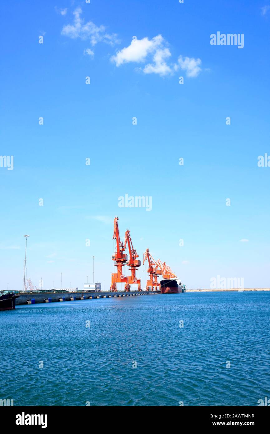 In freight terminal, gantry crane and cargo ships are in loading and ...