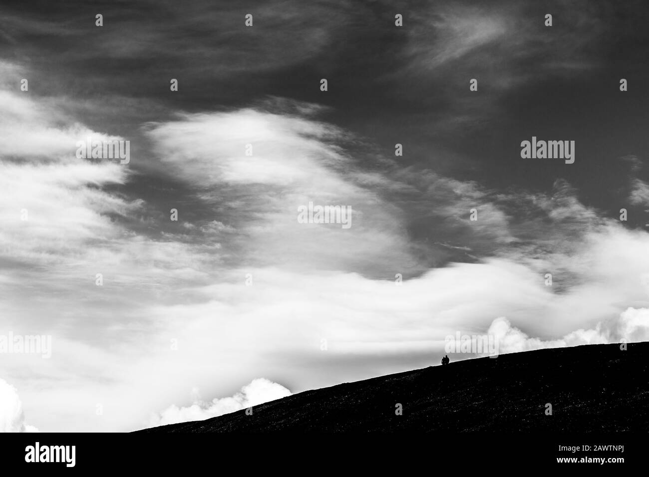 Mountains view in spring with two distant people beneath a big, deep ...