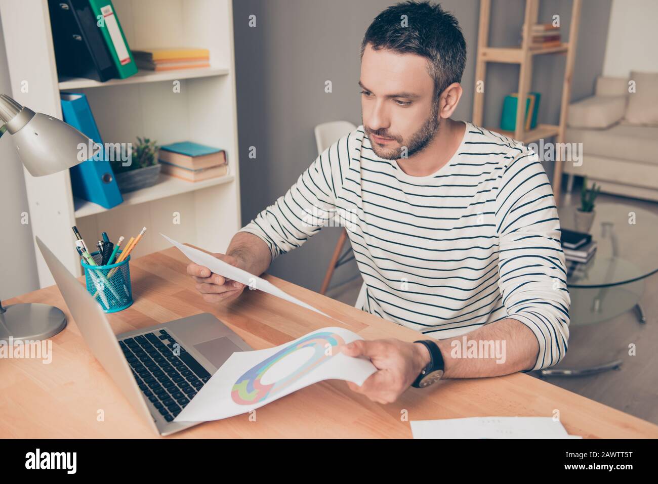 Portrait of concentrated businessman with laptop doing paperwork Stock ...