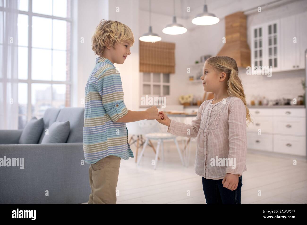 Boy and girl clenching little fingers in the kitchen Stock Photo - Alamy