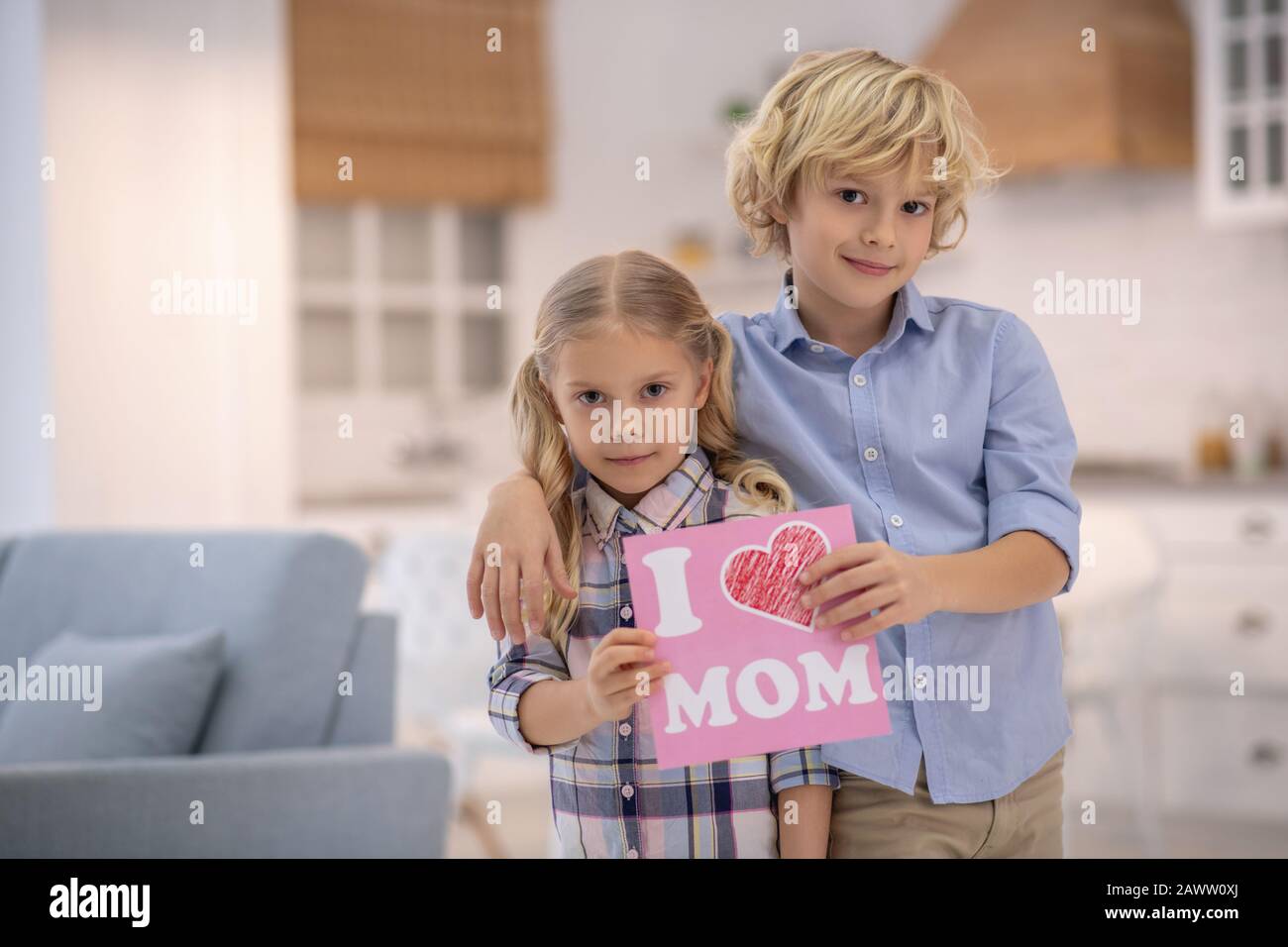 Boy hugging girl, both kids holding sign Stock Photo - Alamy