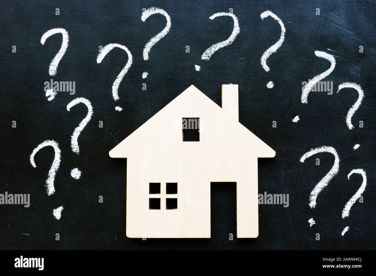Question marks and model of home. Mortgage or buy and rent property ...