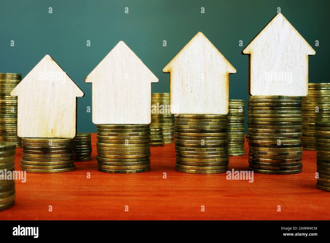 Real estate investment concept. Stacks of coins and small homes Stock ...