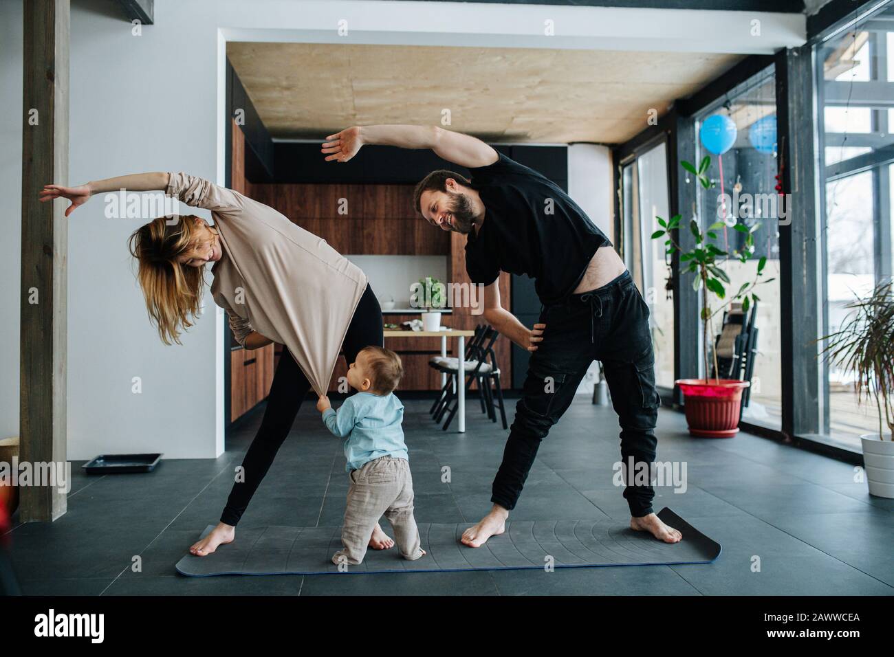 Mother and father doing morning exercises while spending time with ...