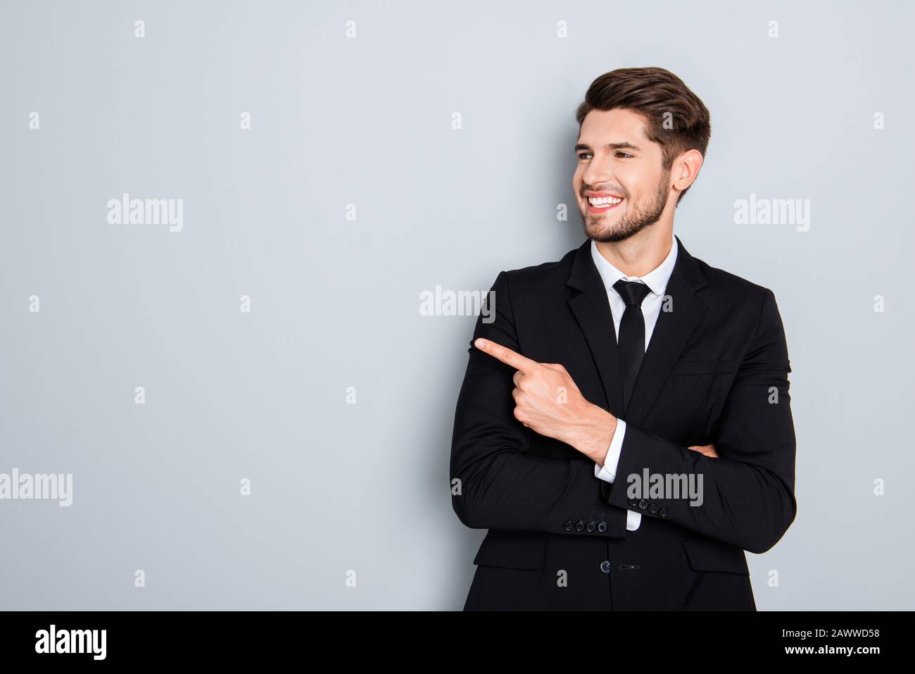 Happy handsome man showing way and pointing with finger Stock Photo - Alamy