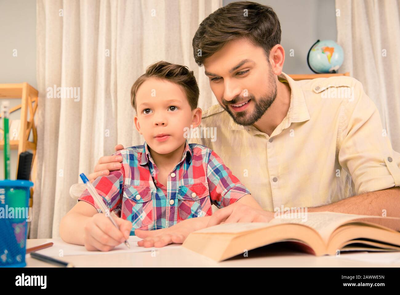 Young father teaching little son how to write Stock Photo - Alamy