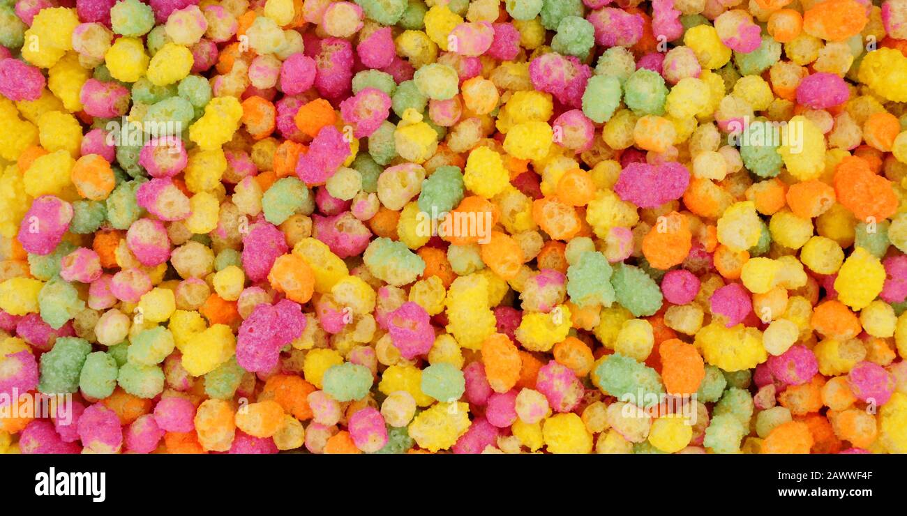 Rainbow coloured puffed maize and rice confectionery background Stock ...