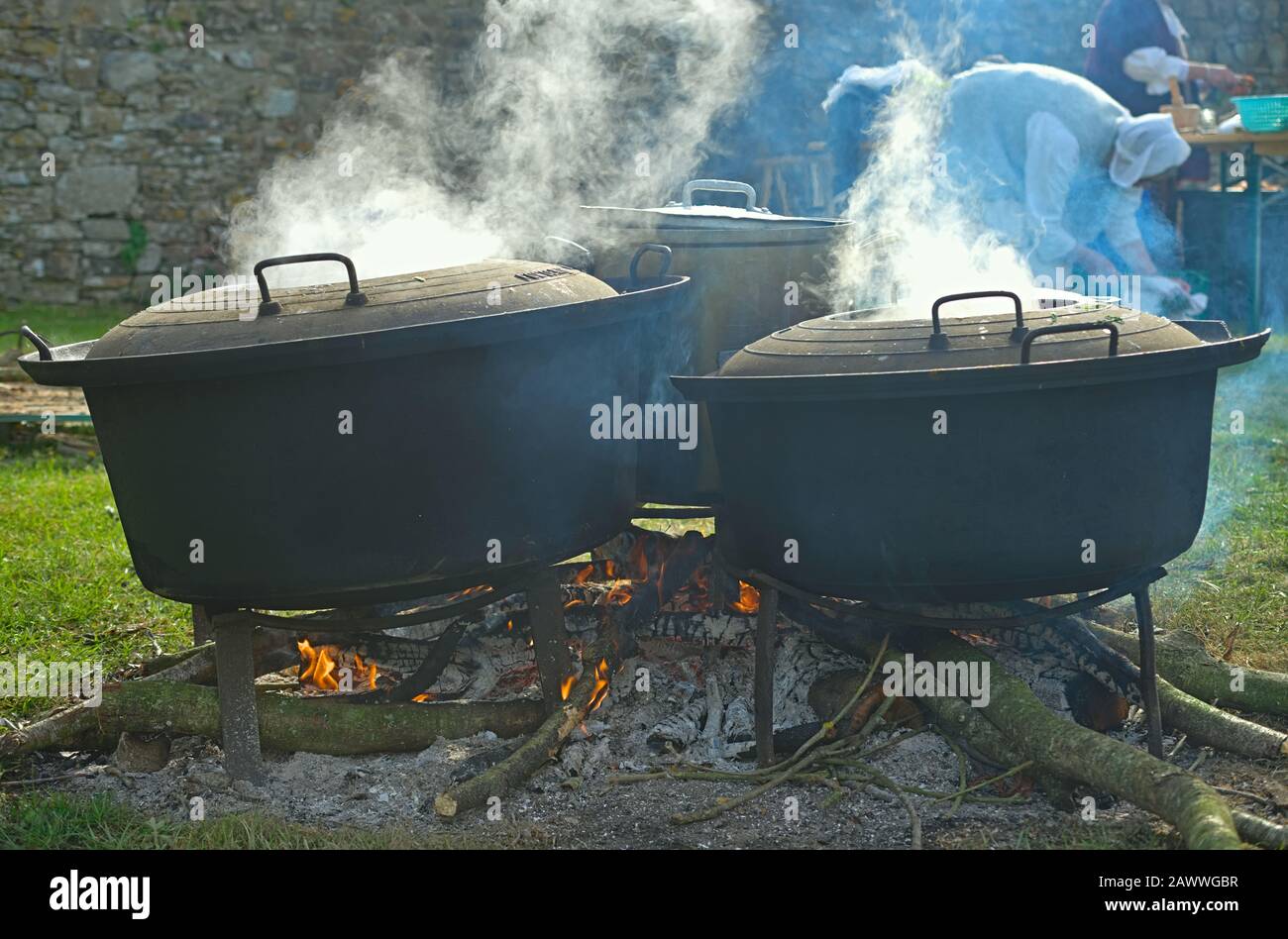 Medieval style of preparing food with three pots cooking on wood Stock ...