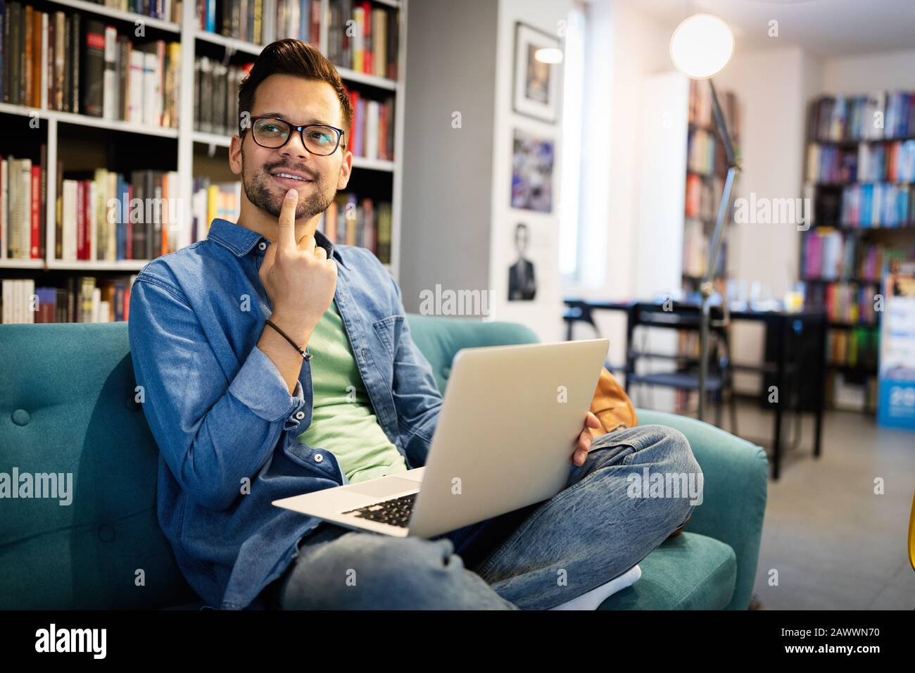Smiling male student working and studying in a library Stock Photo - Alamy