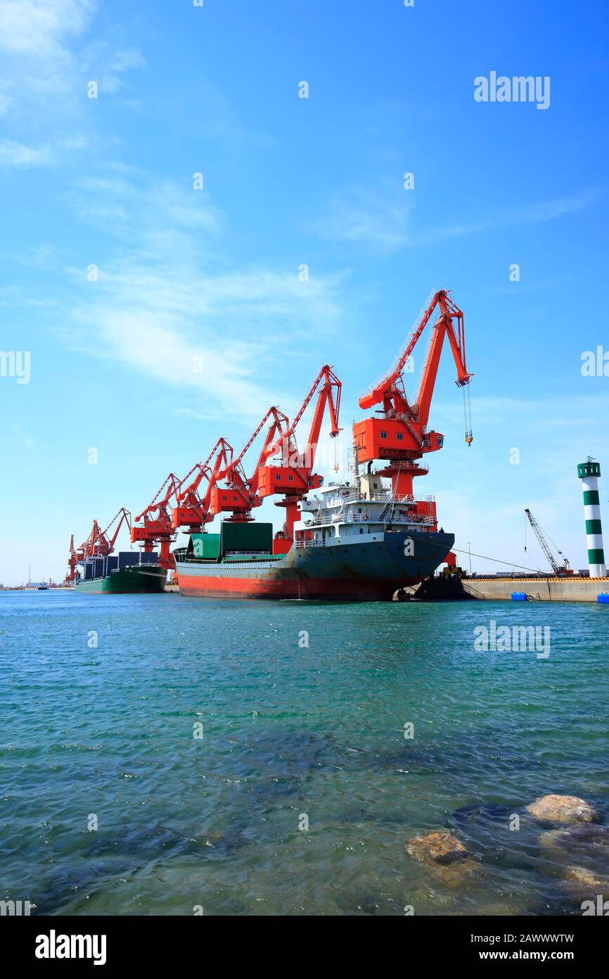 In freight terminal, gantry crane and cargo ships are in loading and ...