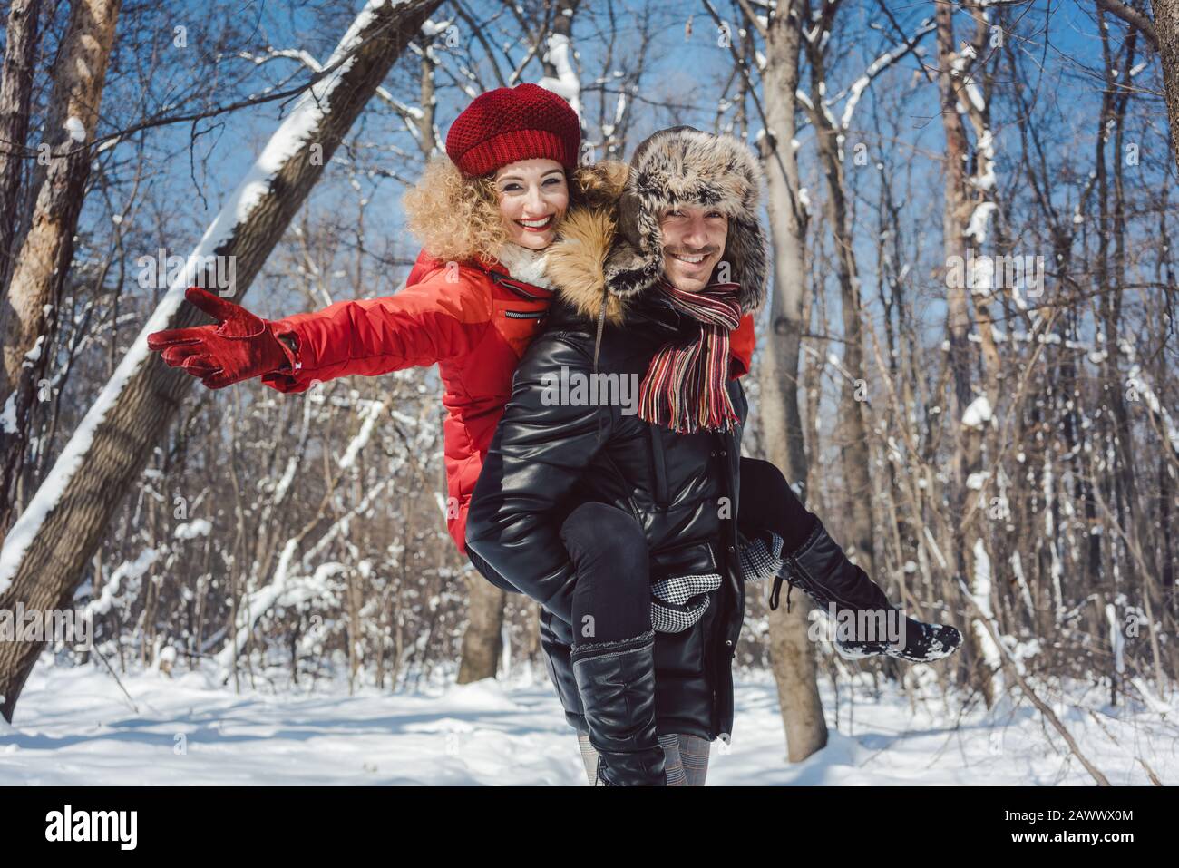 Man carrying his woman piggyback on a winter day Stock Photo - Alamy