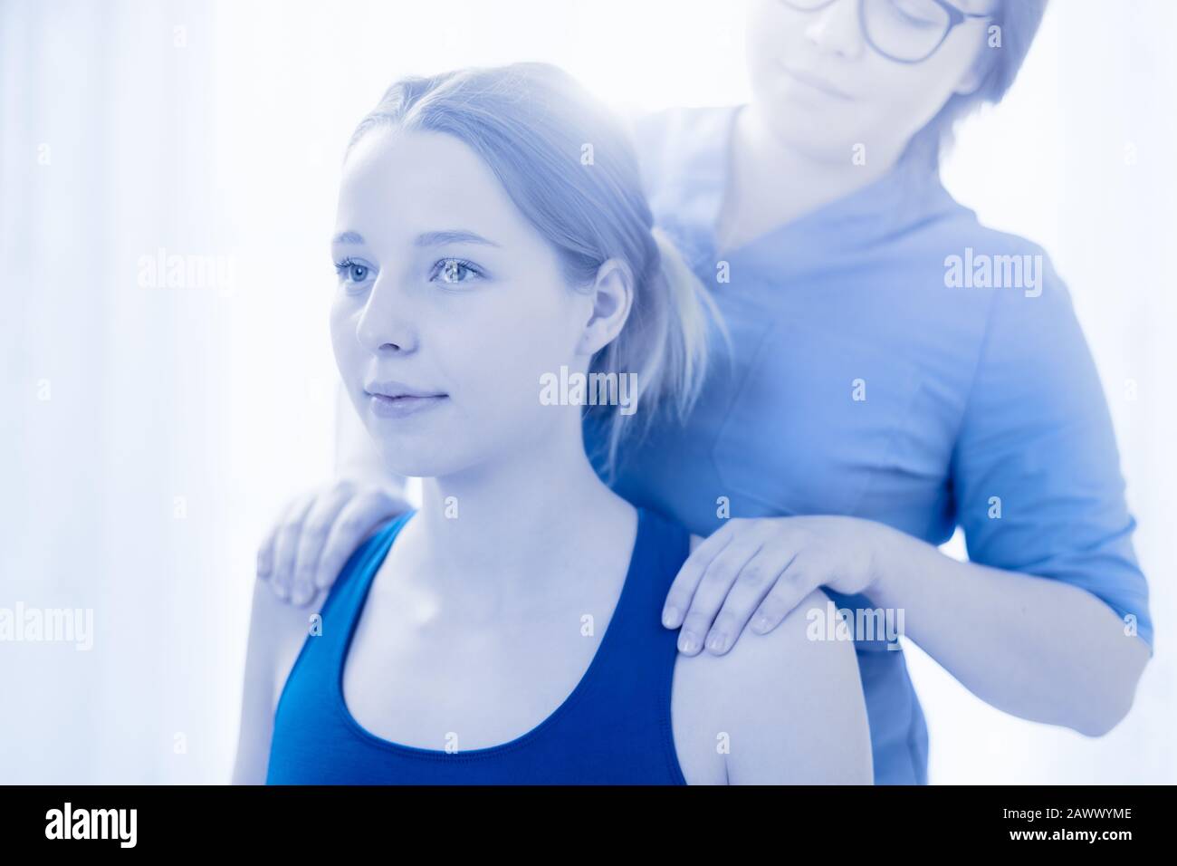 Female physiotherapist or a chiropractor examining patients back ...
